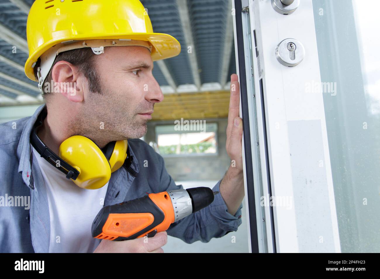 a builder drill a plastic window Stock Photo - Alamy