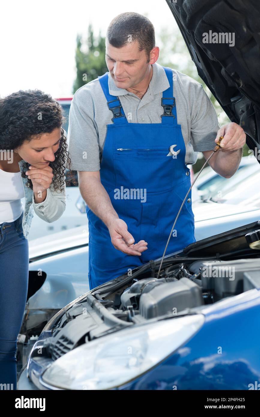 male mechanic checking car with owner car on roadside Stock Photo - Alamy