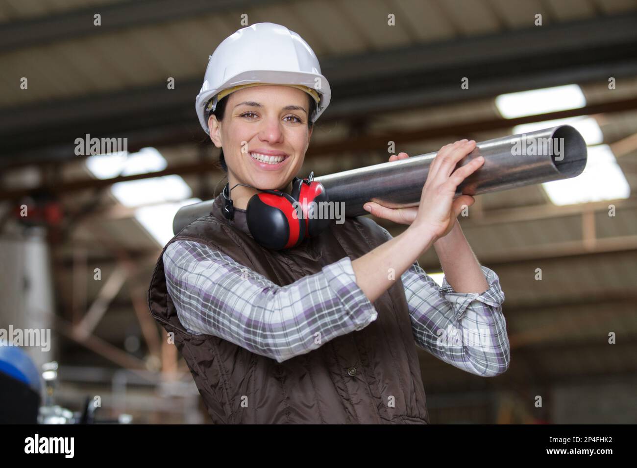 happy woman in dungarees carrying plastic pipes Stock Photo - Alamy