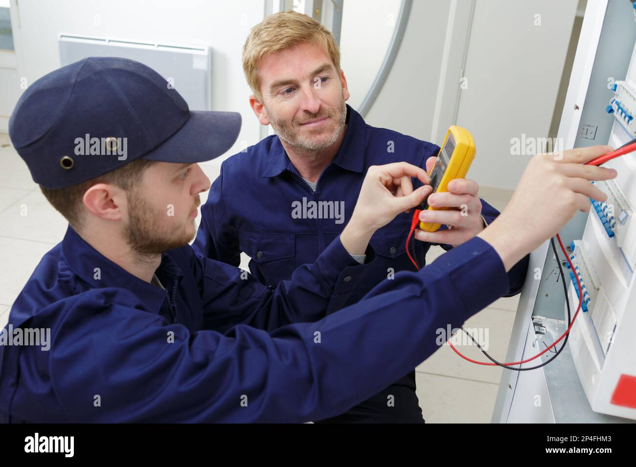 apprentice electrician measuring voltage in distribution board Stock ...