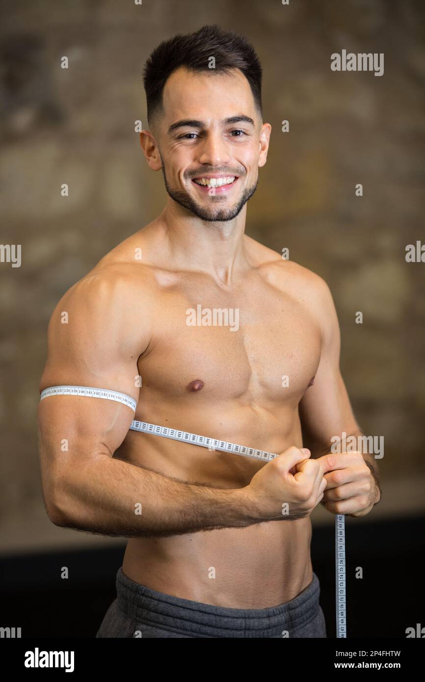 man measuring biceps with measuring tape Stock Photo - Alamy