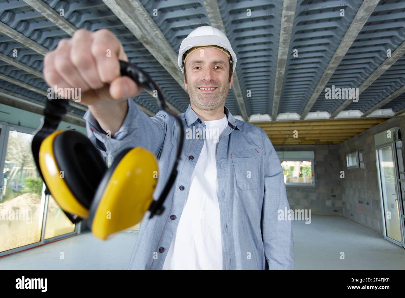 workman shows the ear protection Stock Photo - Alamy