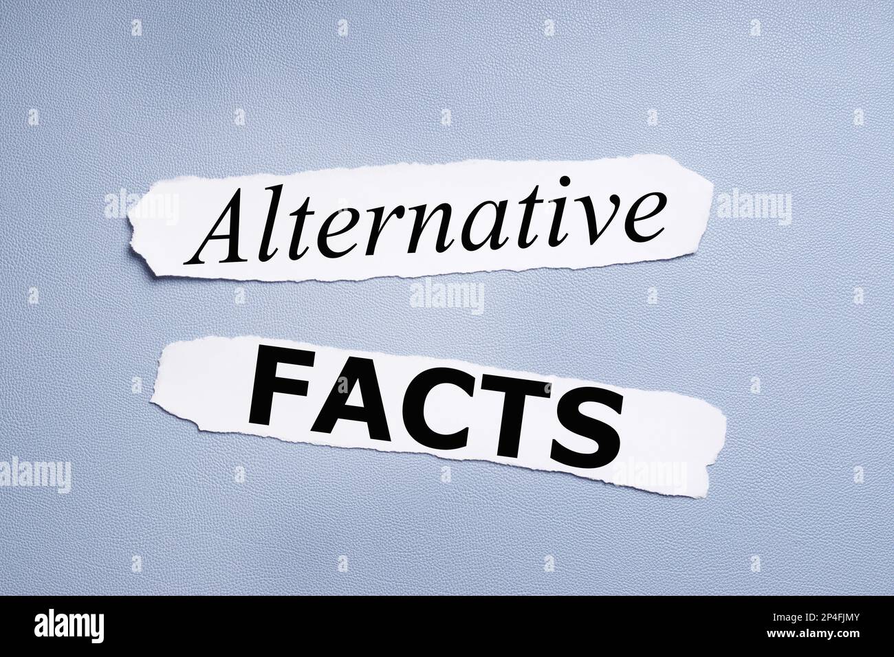 alternative facts, phrase printed on pieces of paper over blue ...