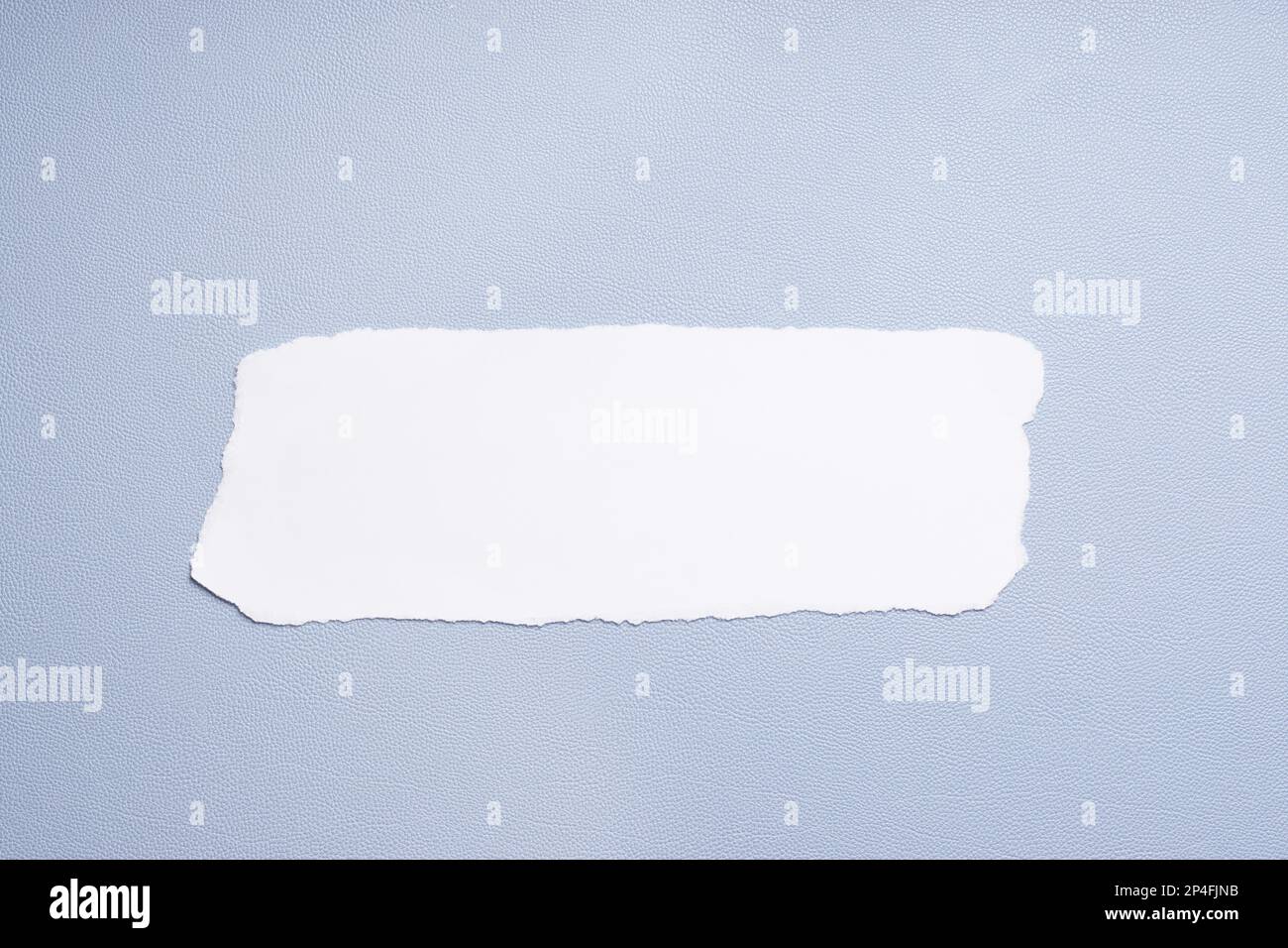 blank torn strip of paper with copy space on blue desk pad background ...