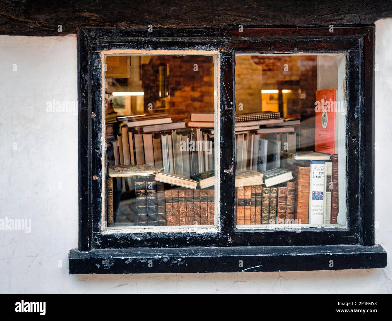 View through an old window on stacks of books, antiquarian bookshop ...