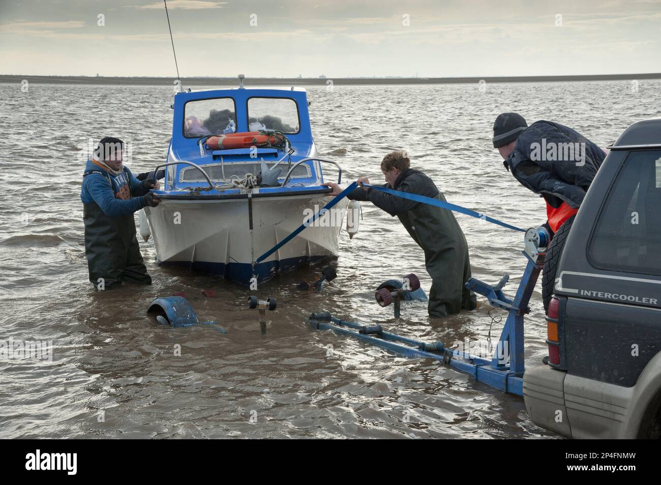 Licensed cockle pickers landing boat and unloading after picking from ...