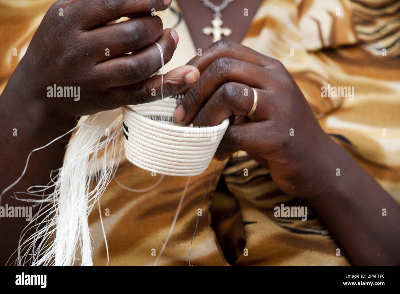 Close-up of a lady weaving a traditional basket at the Ladies ...