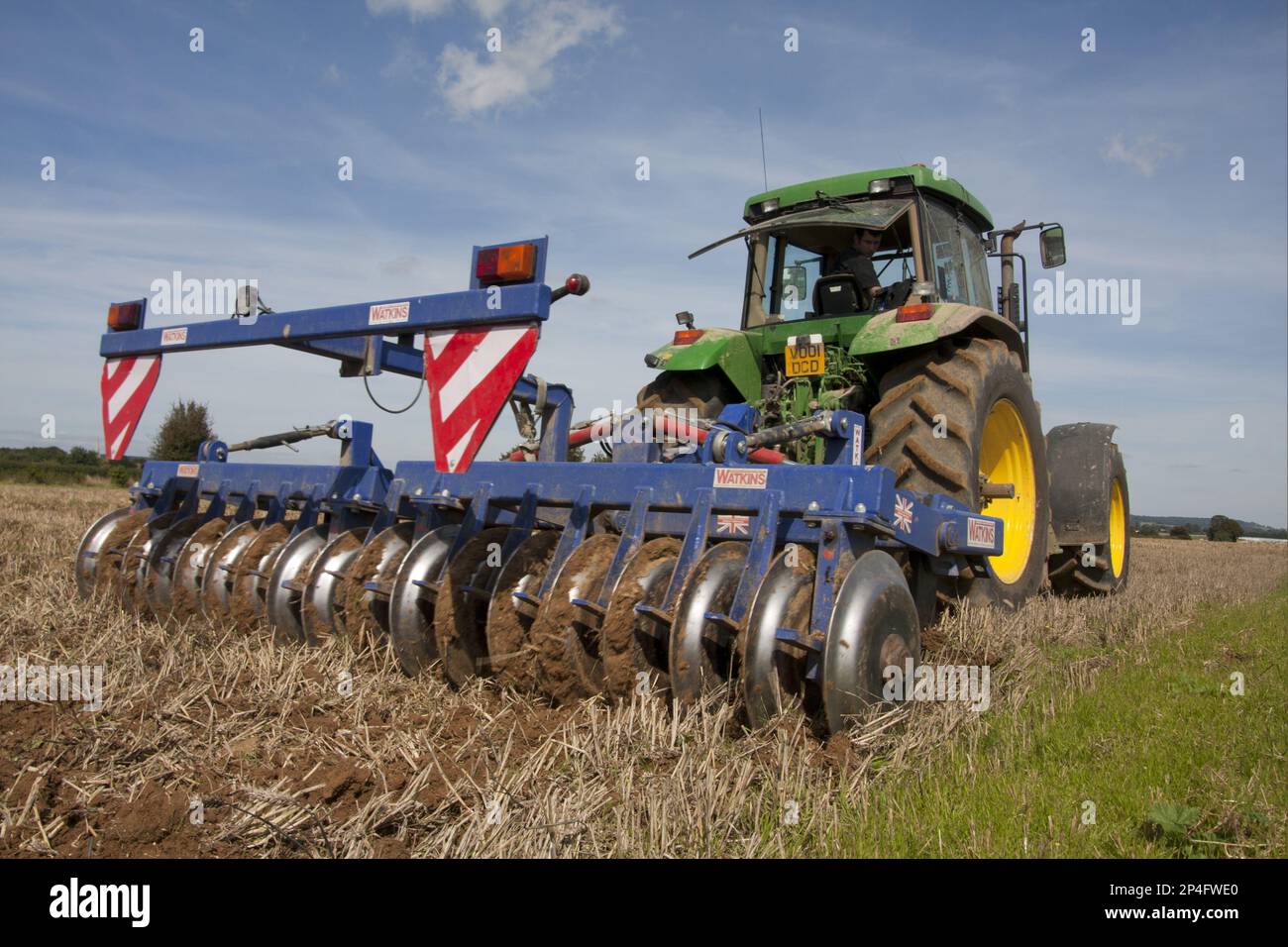 Tractor with disc harrows, harrow stubble field, Sussex, England ...