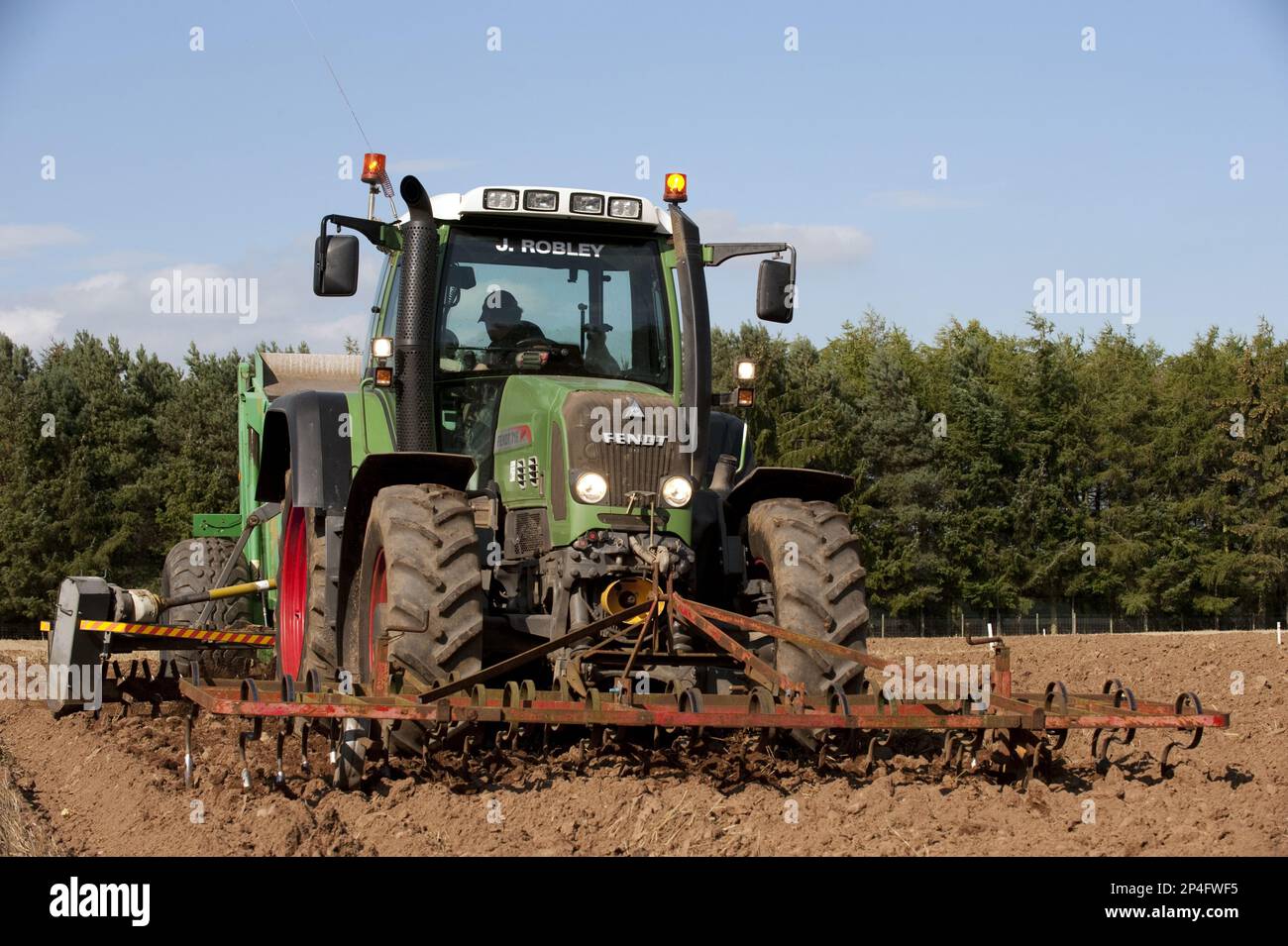 Fendt tractor 716 with stone picker, driving over newly ploughed field ...