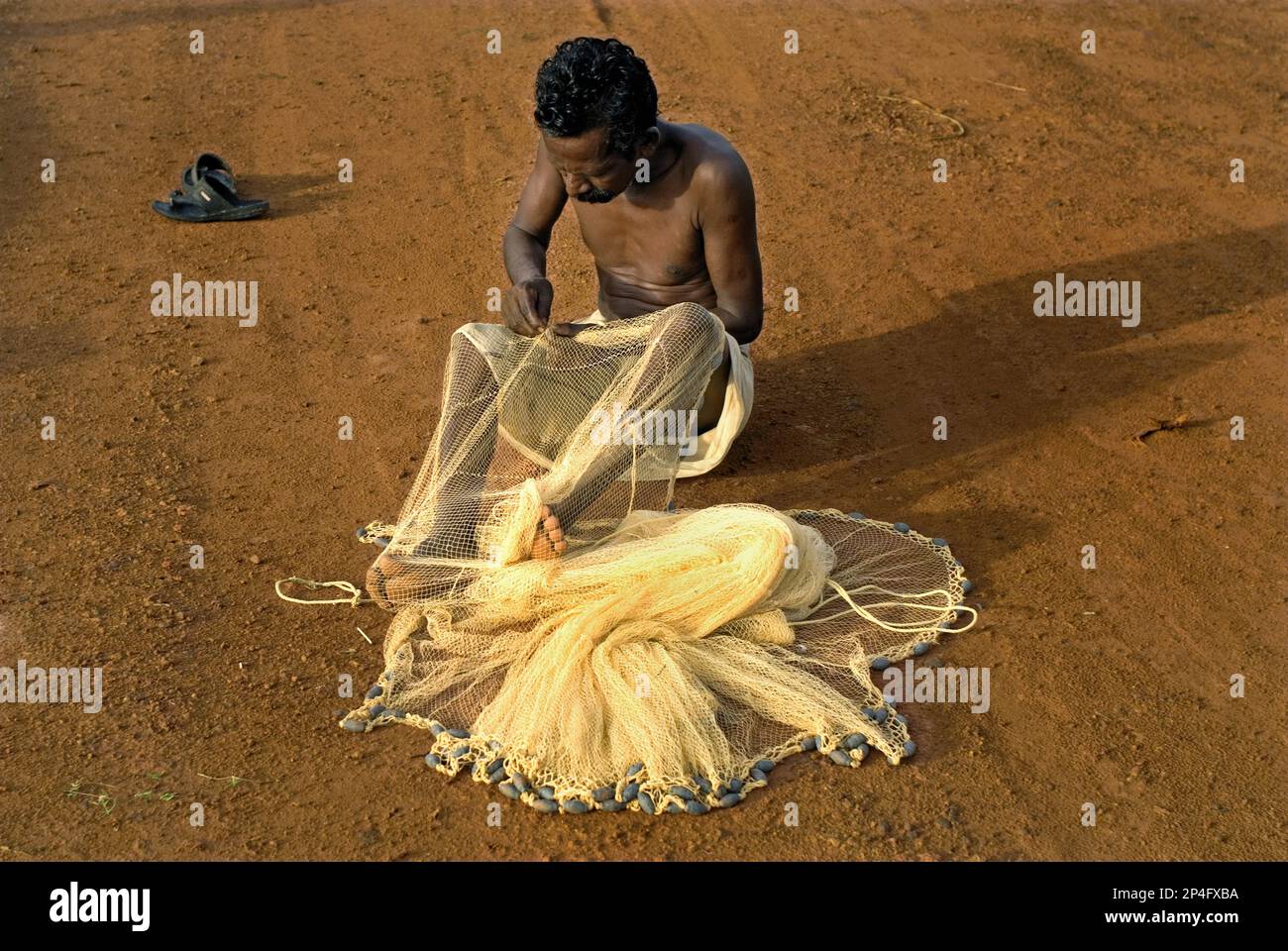 Fishermen mending nets on the beach, Trivandrum, Kerala, India Stock ...