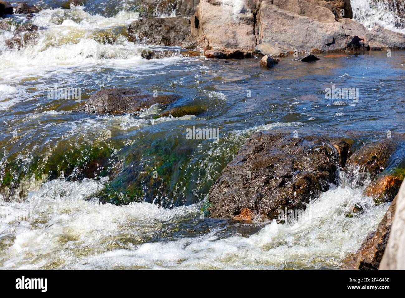 The rapid flow of a mountain river through stone rapids and foaming ...