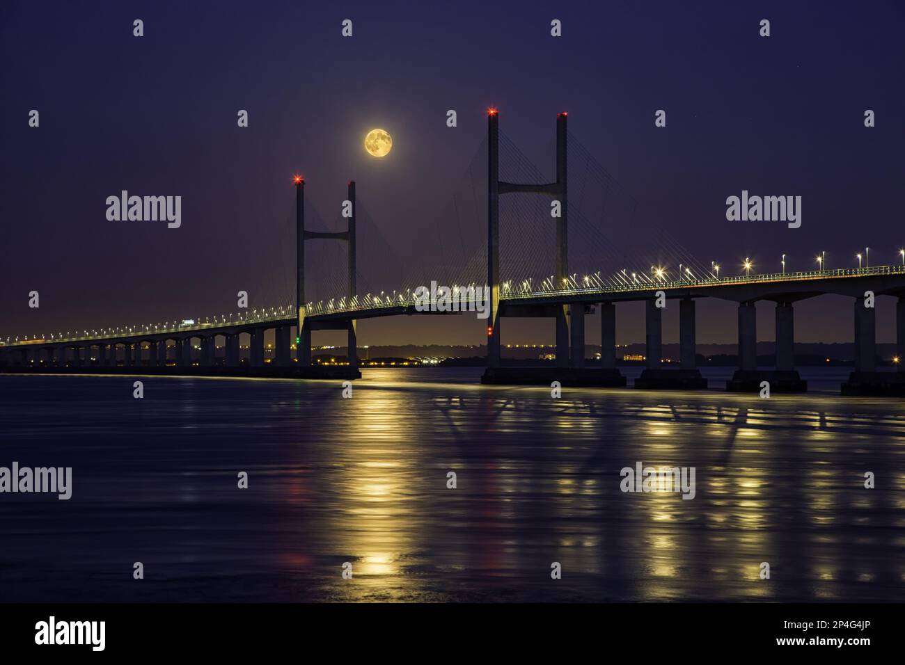 View of road bridge over river at dusk under full moon, seen from Diver ...