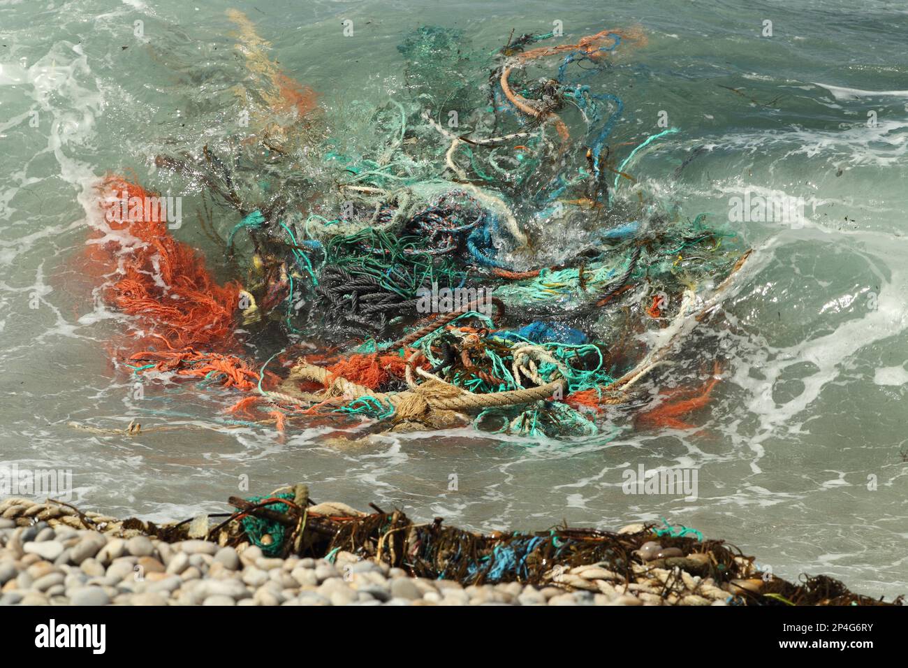Large trawl net washing in from sea, Chesil Beach, Dorset, England ...