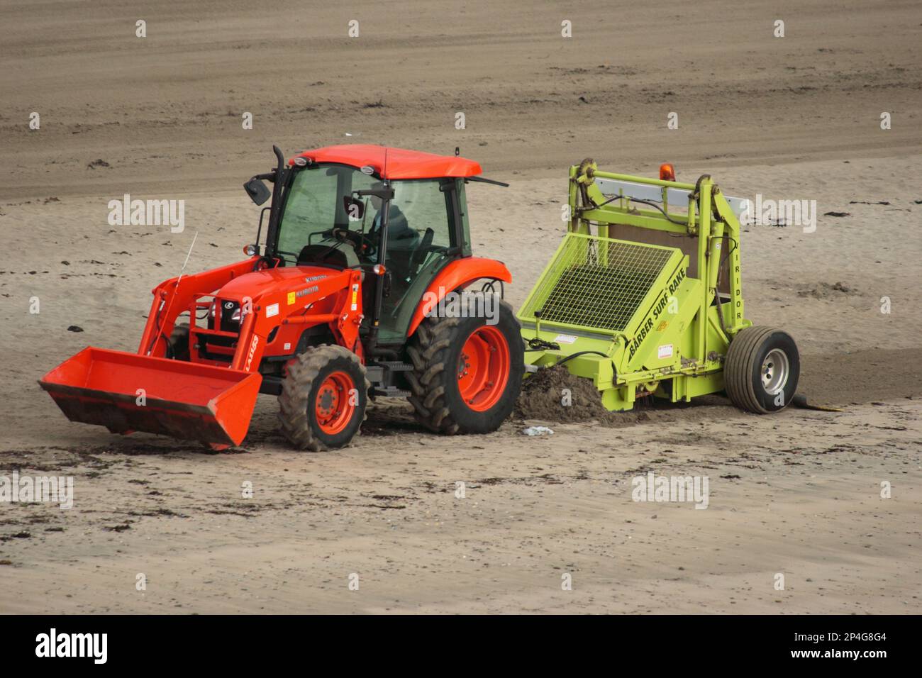 Mechanical beach cleaning, tractor with surf rake raking beach ...