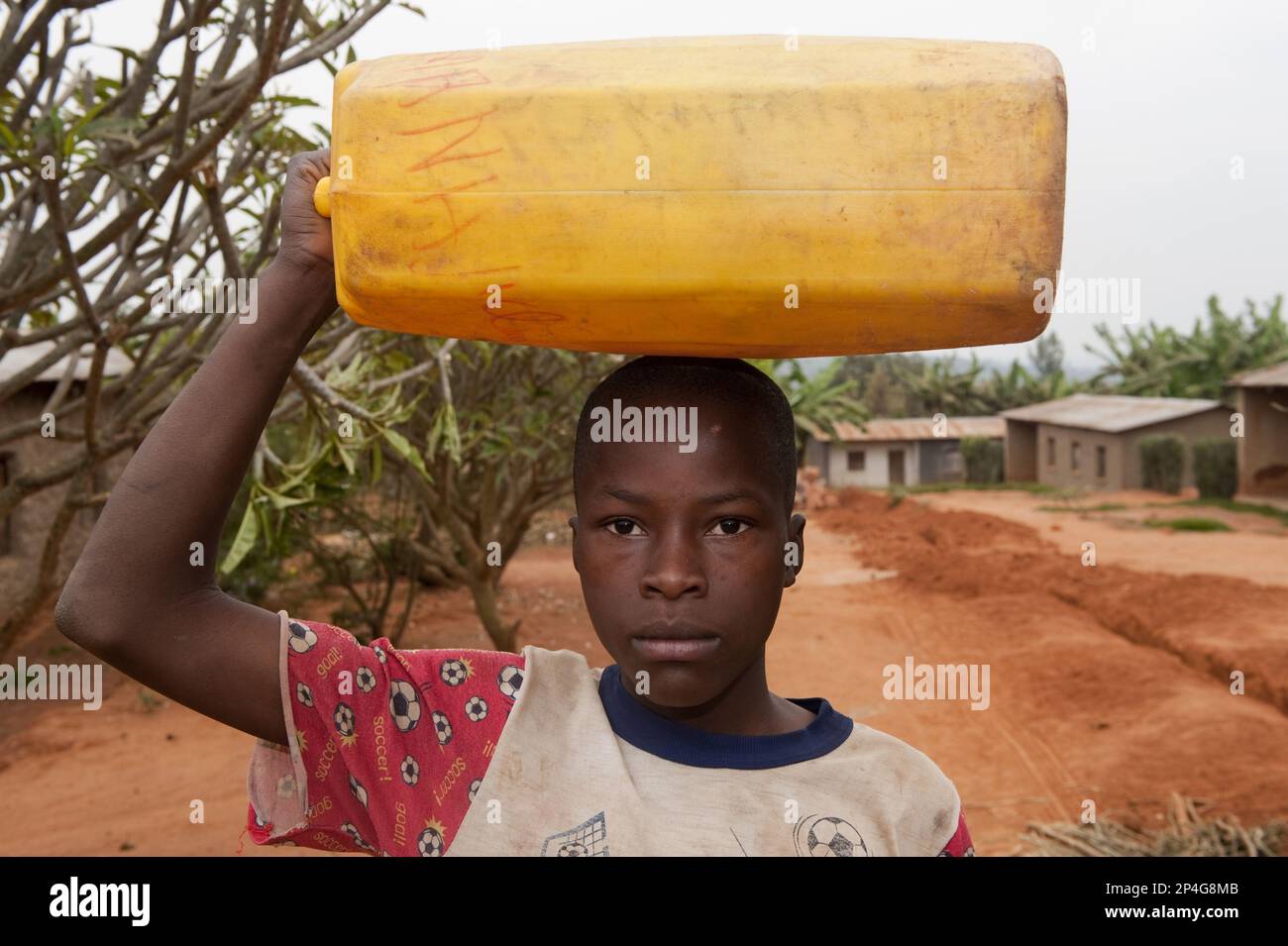 Children collecting water from a well and carrying it home, Rwanda ...