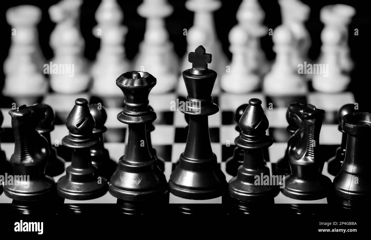 Close up of Chess pieces on a reflective mirror board surface with a ...