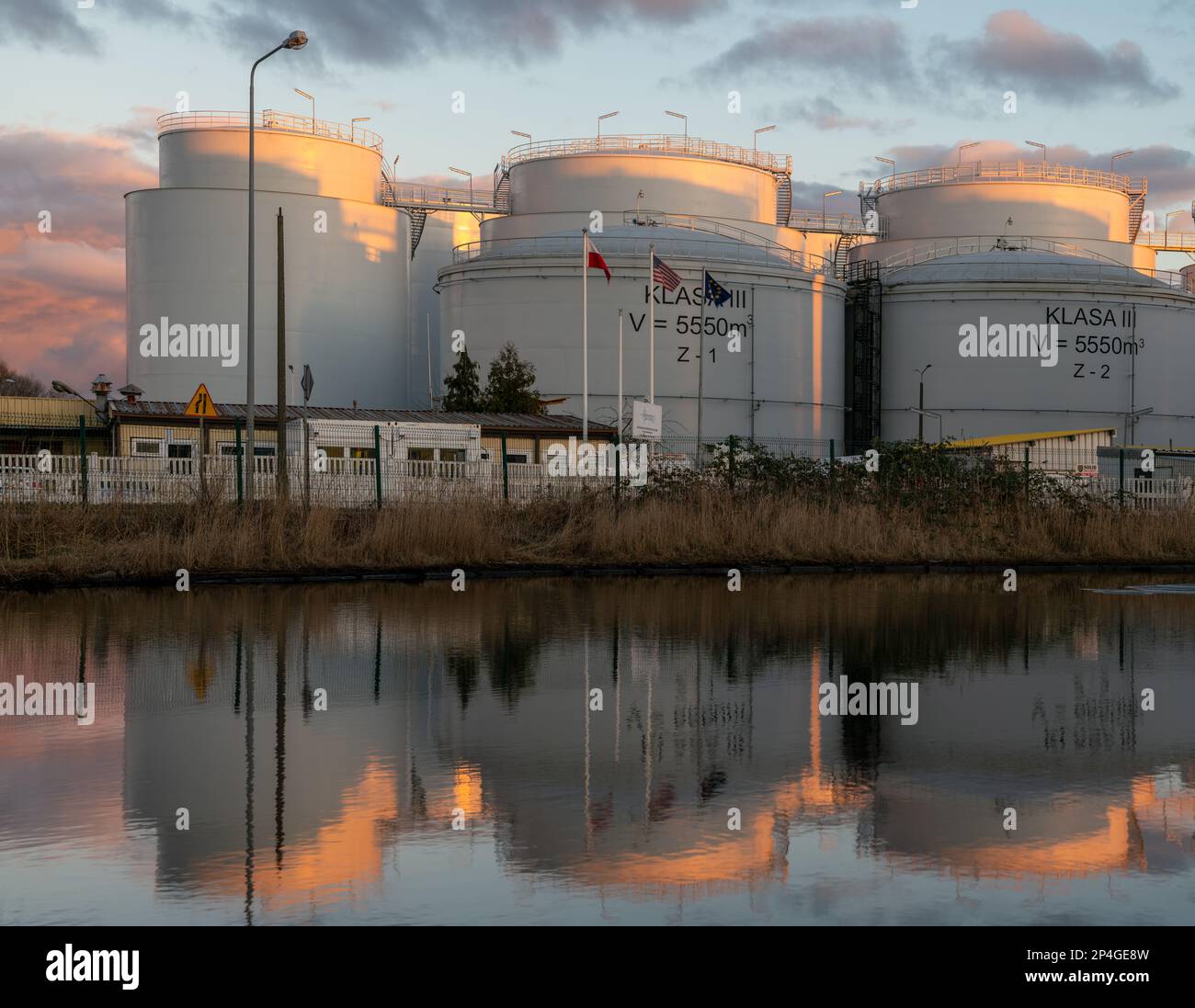 Liquid fuel storage facilities reflected in water mirror Stock Photo ...