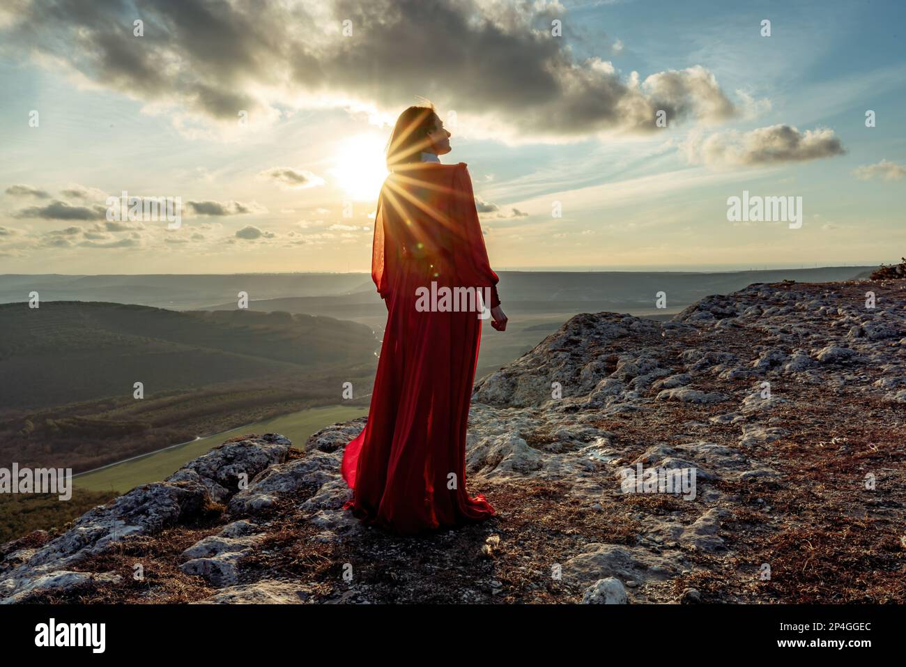 Rise of the mystic. sunset over the clouds with a girl in a long red ...