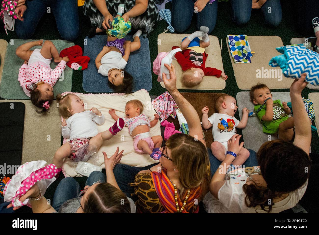 Melissa Healey, bottom left, and Carley Pettey, raise their cloth ...