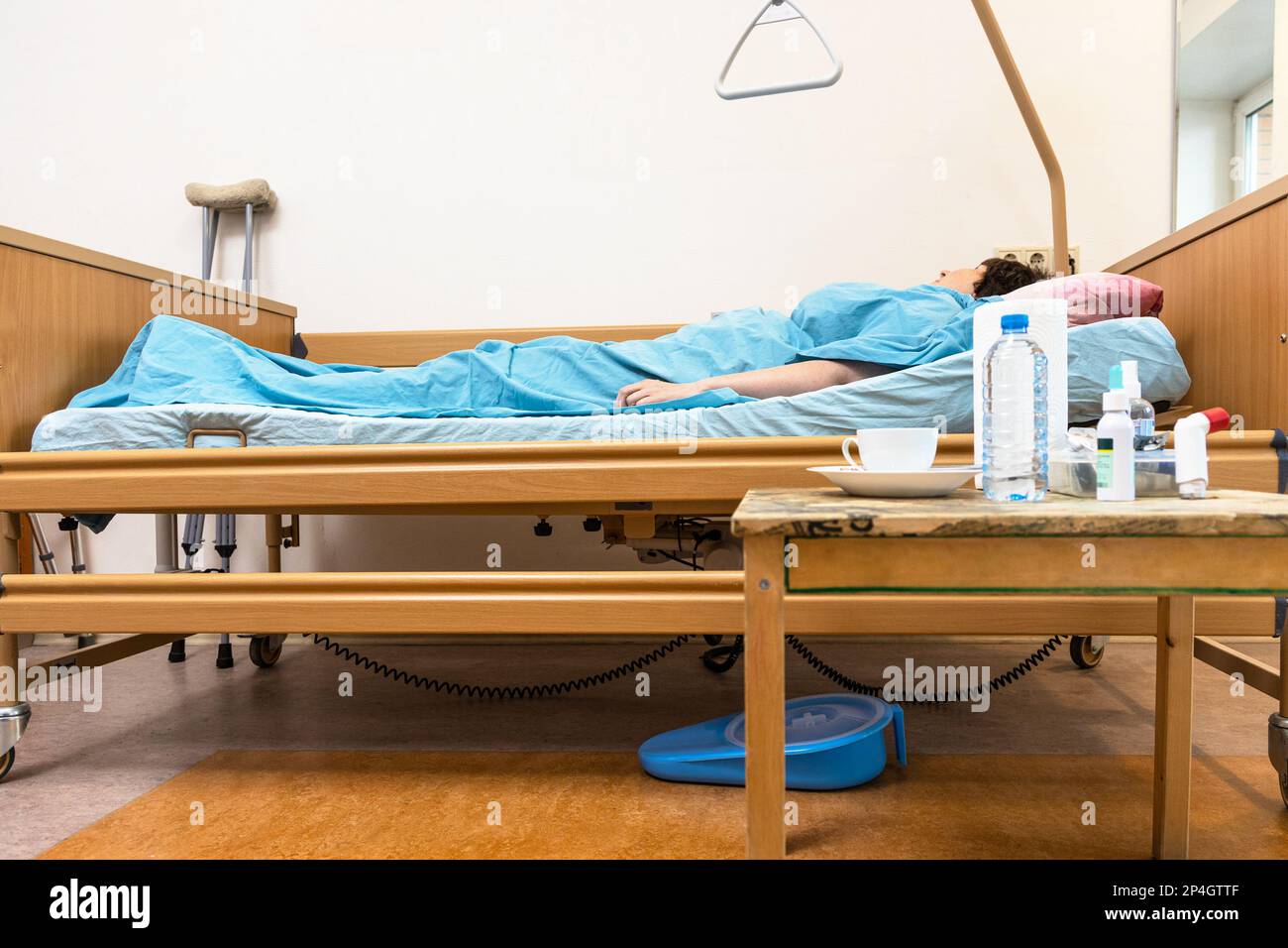 side view of homecare adjustable electric hospital bed with sick person ...