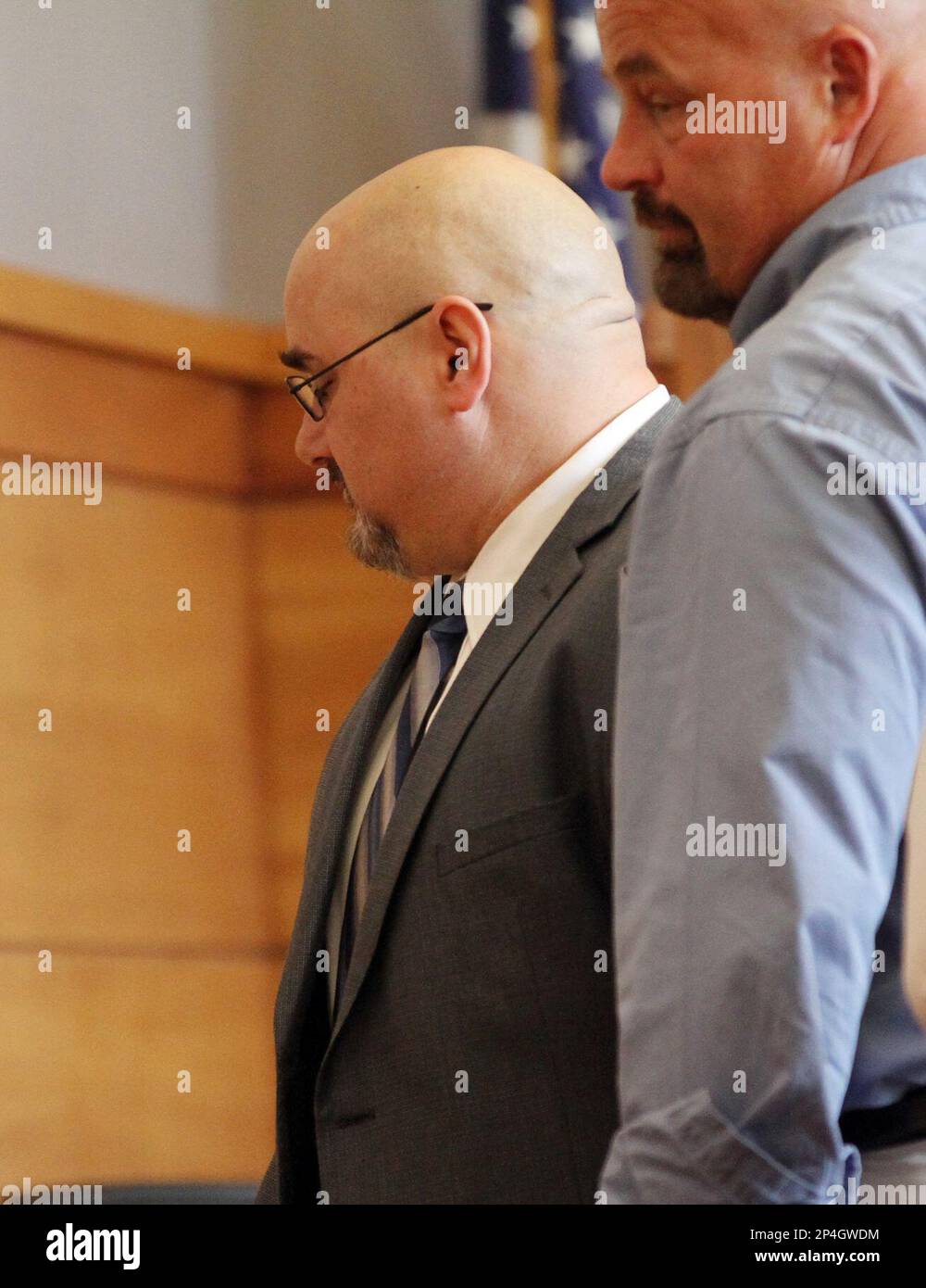 Ipswich, Mass., police officer Peter Nikas, left, walks to a holding ...