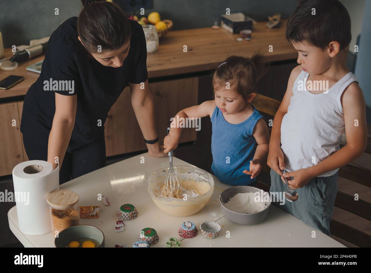 Cute lttle baby girl and boy learning how to mix ingredients in bowl ...