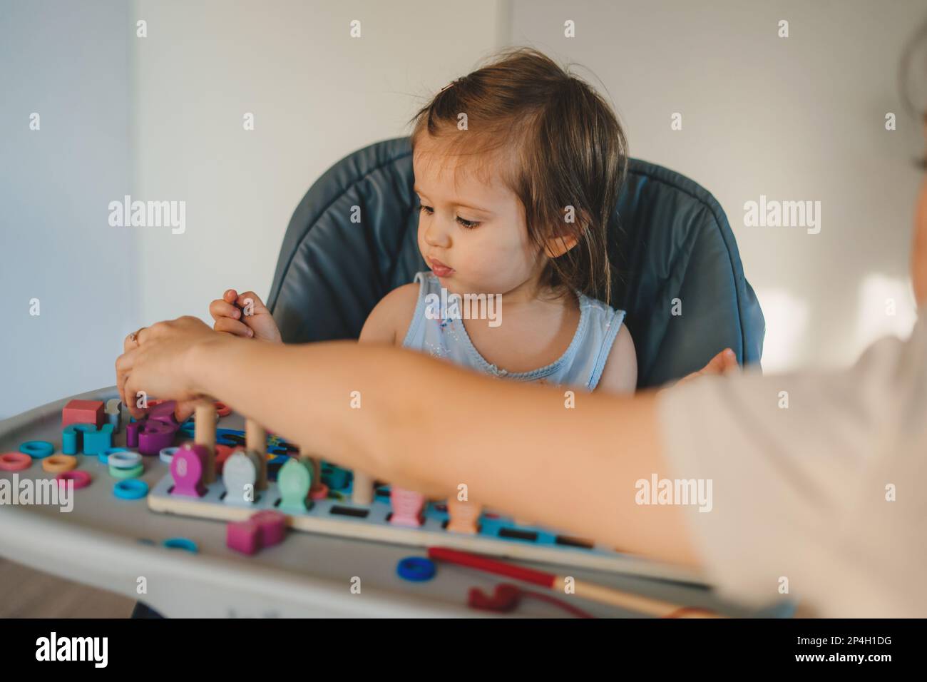 Baby child playing with different color wooden forms. Fine motor skills ...
