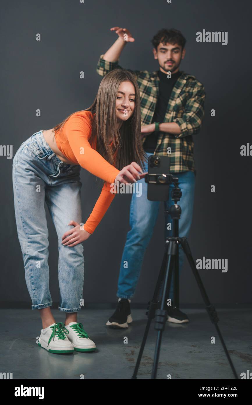 Two young caucasian bloggers recording dancing process with smartphone ...