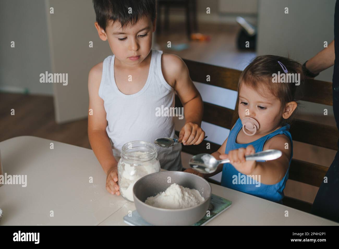 Happy family cooking together in the kitchen while little baby girl ...