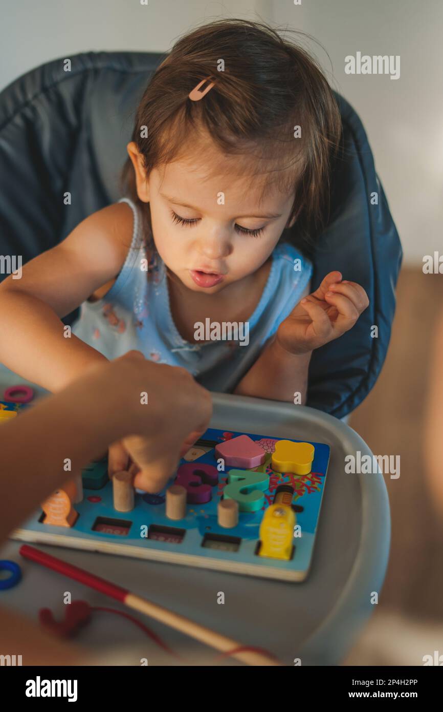 Mother teaching the baby girl to count playing with colorful toys ...