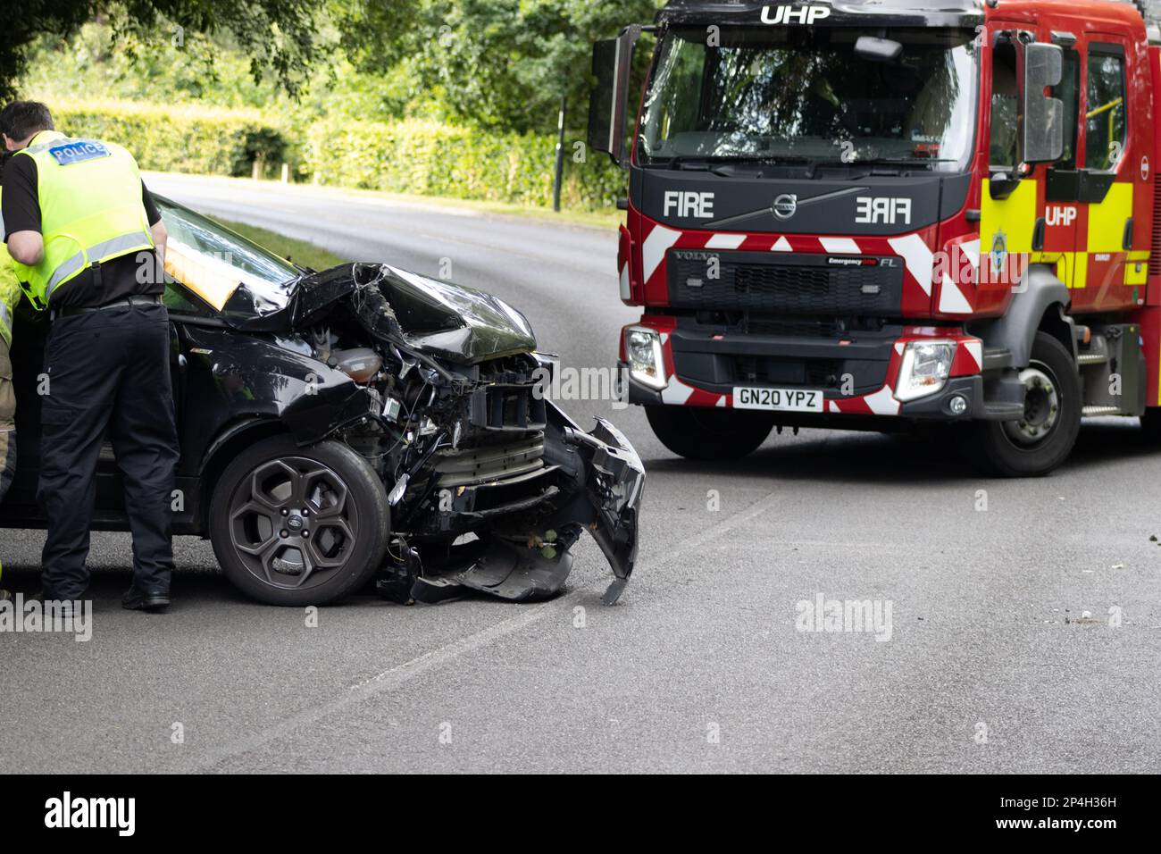 Crashed car with fire engine in background Stock Photo - Alamy