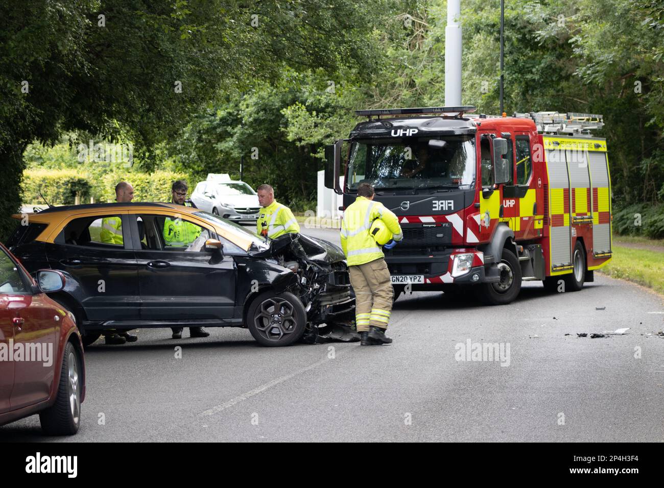Crashed car surrounded by fire fighters and engine behind Stock Photo ...