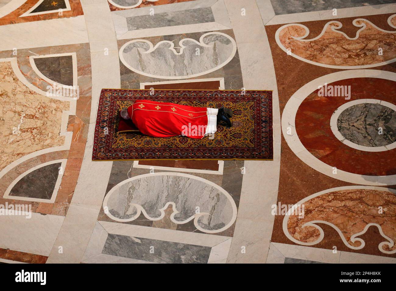 Pope Francis lays prostrate on the floor in prayer before presiding ...