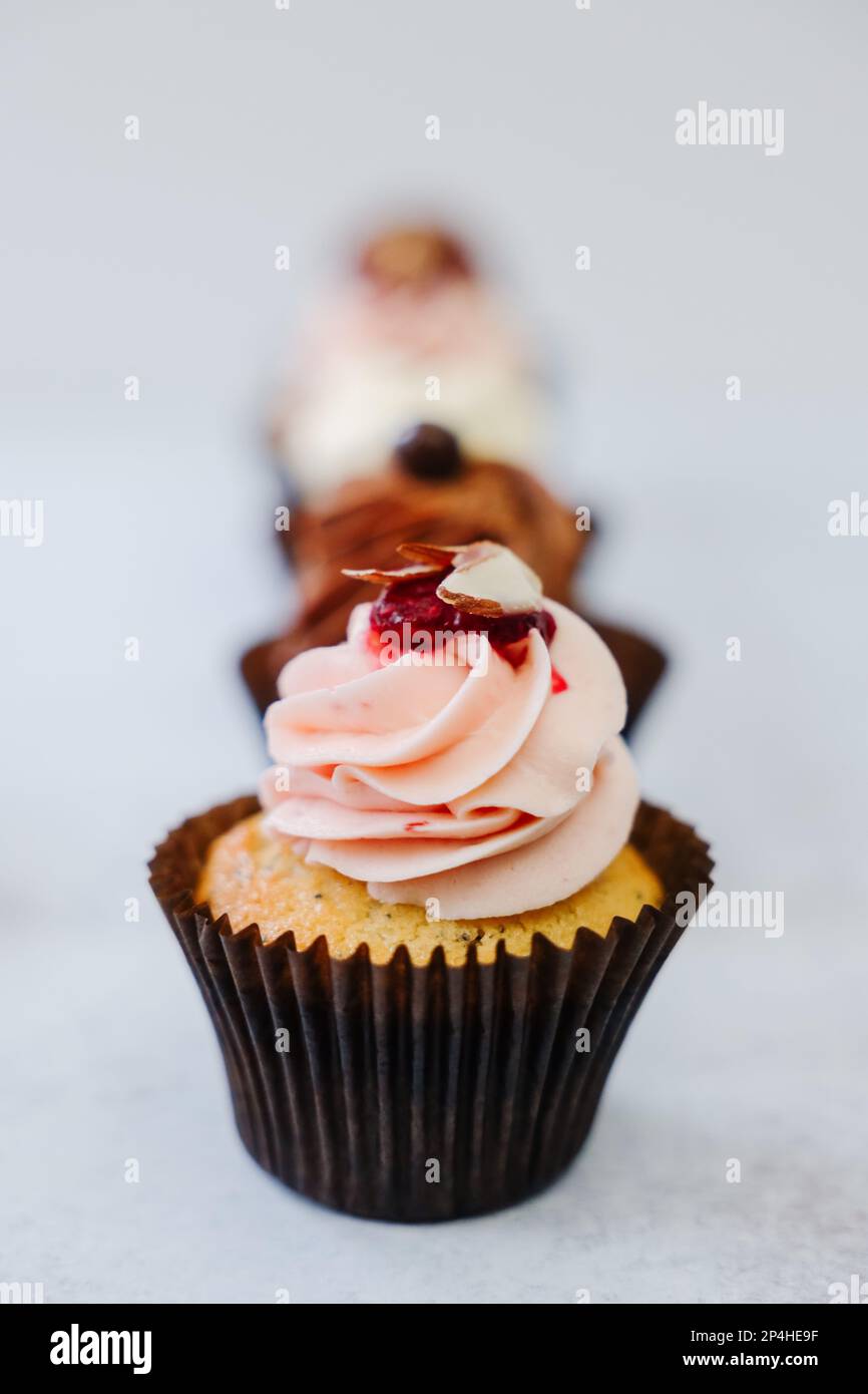 Line of fresh baked cupcakes with thick frosting Stock Photo - Alamy