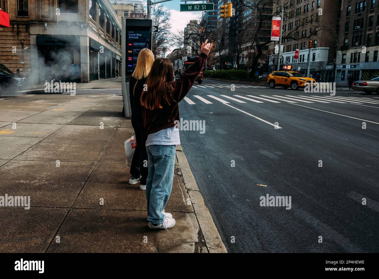 Teen girl hailing cab in New York city Stock Photo - Alamy