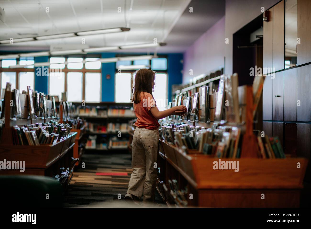 Profile of tween girl looking at library books Stock Photo - Alamy