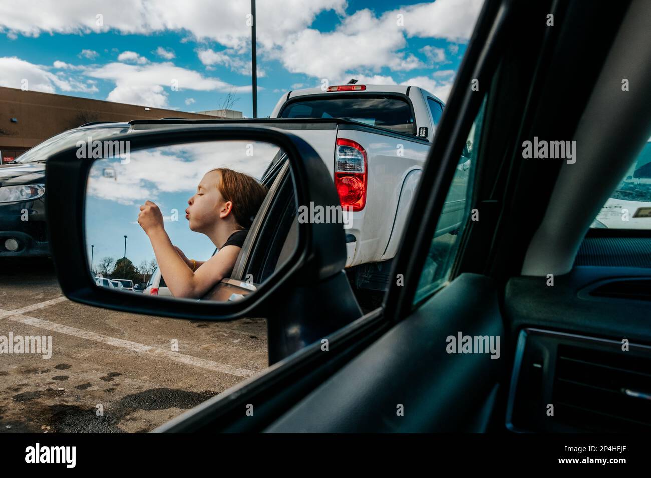 Tween girl blowing bubbles out of car window Stock Photo - Alamy