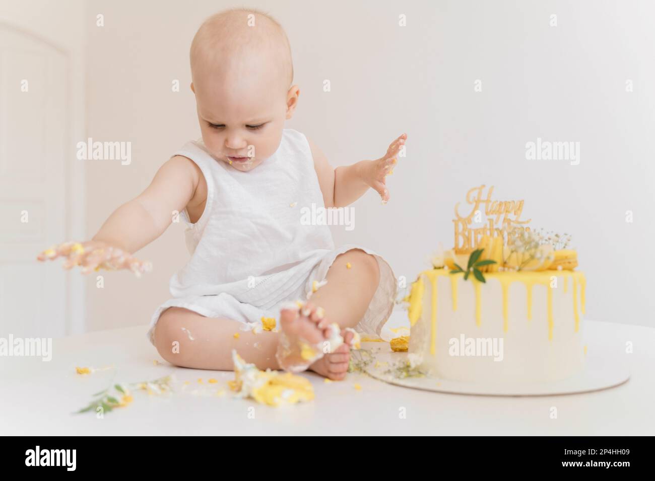 Baby girl eats her first birthday cake with her hands and legs Stock ...
