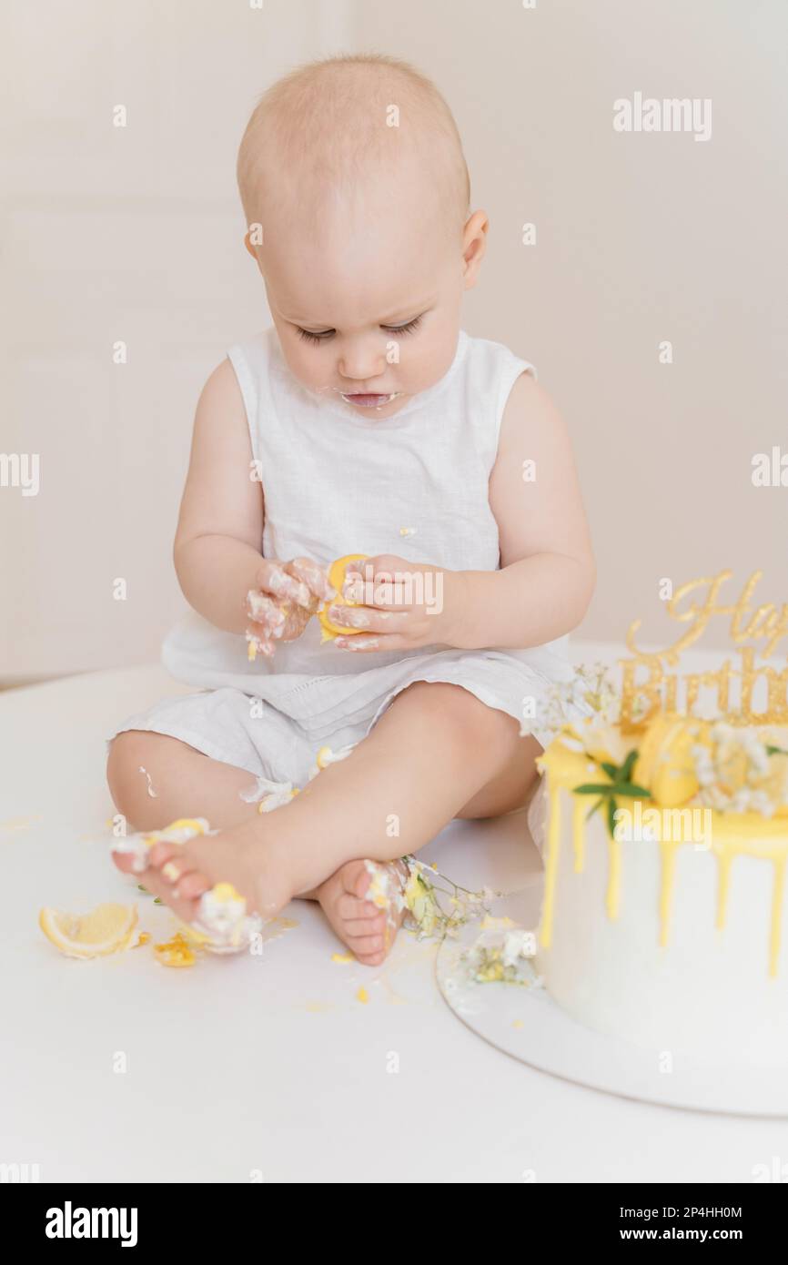 Baby girl eats her first birthday cake with her hands and legs Stock ...