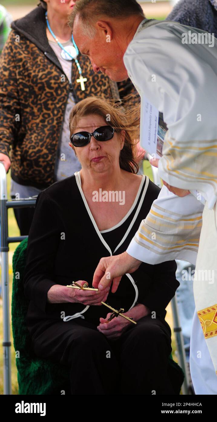Rev. Fr. Rusty Smith hands crucifixes to Barbara Jones the mother of ...