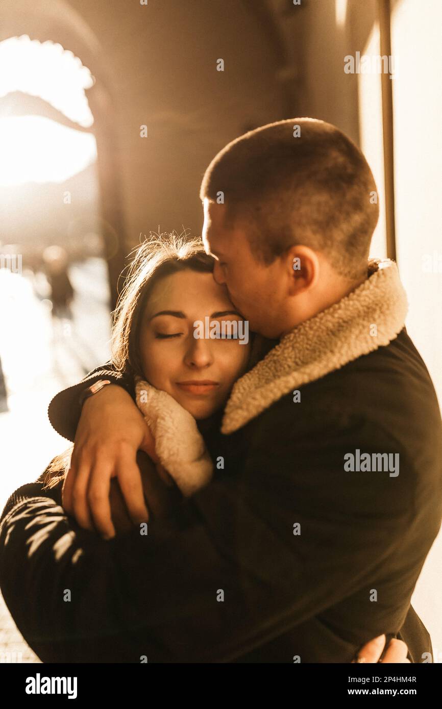 man and a woman are kissing and embracing in rays of autumn sun Stock ...