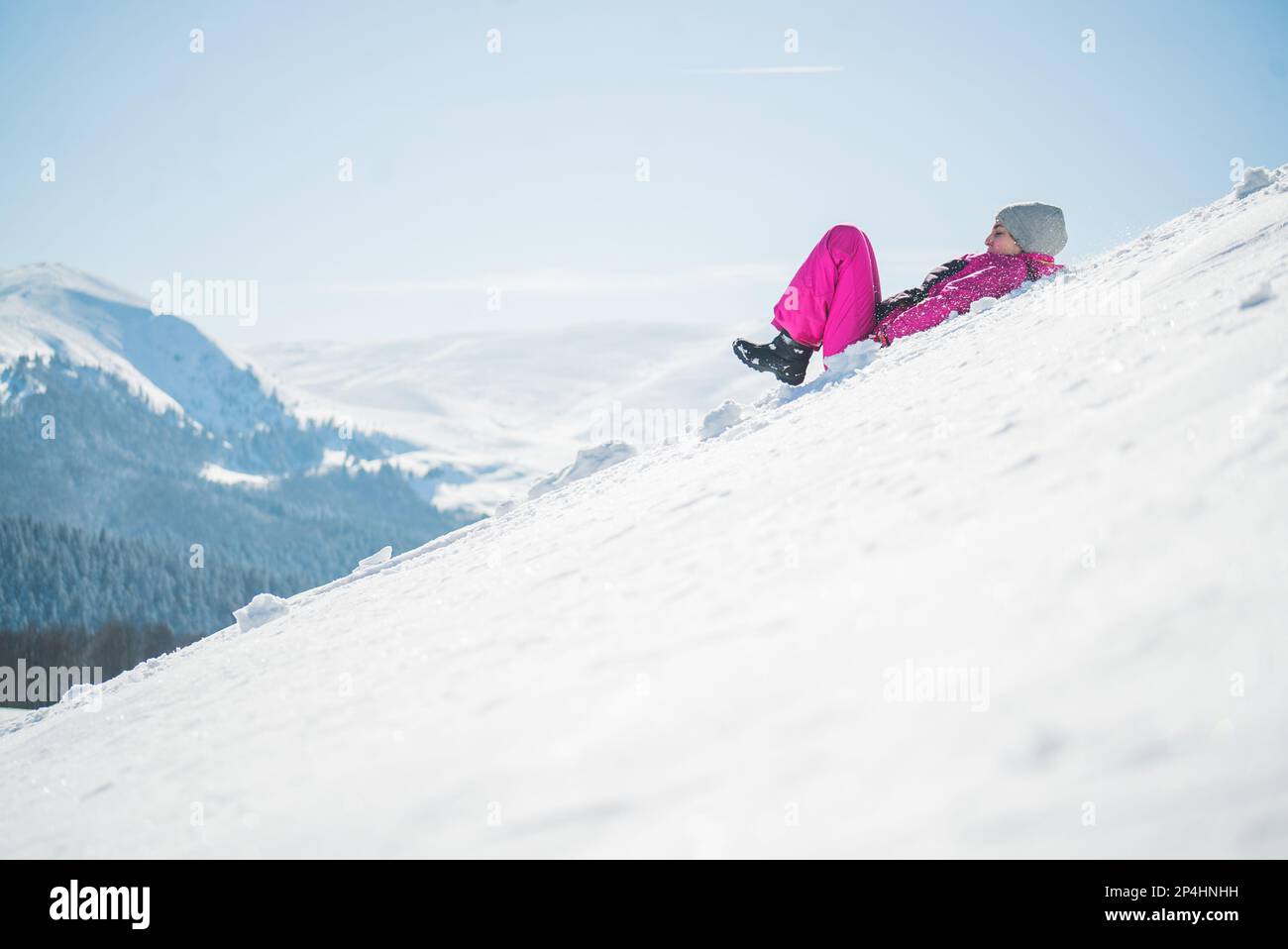 Winter Sliding Girl on Steep Slope in the Mountains Stock Photo - Alamy