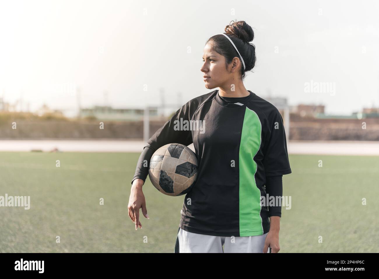 Latin woman football player holding a football Stock Photo - Alamy