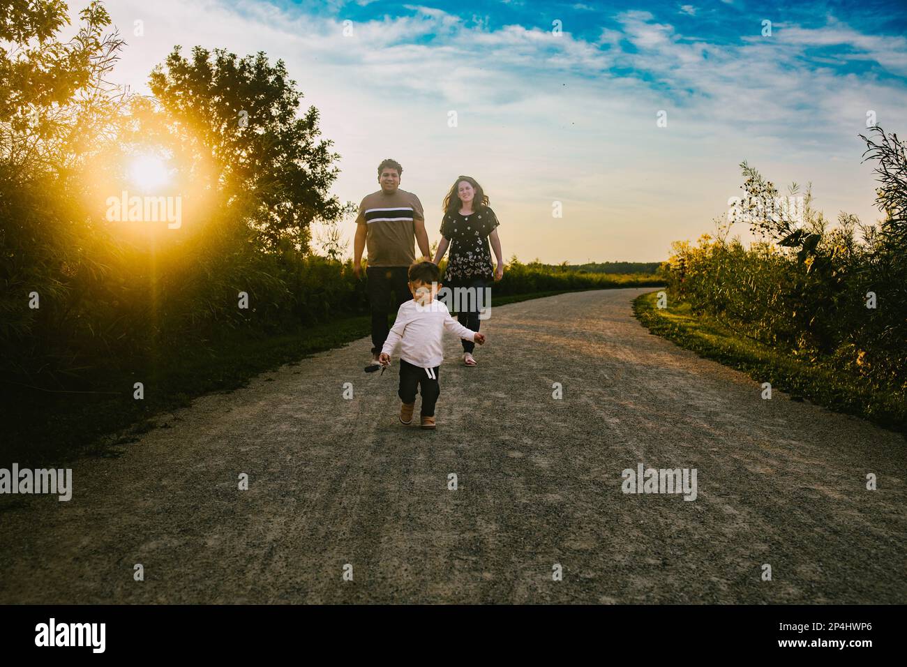 Family walks along a path in summer outside in nature and sunshine ...