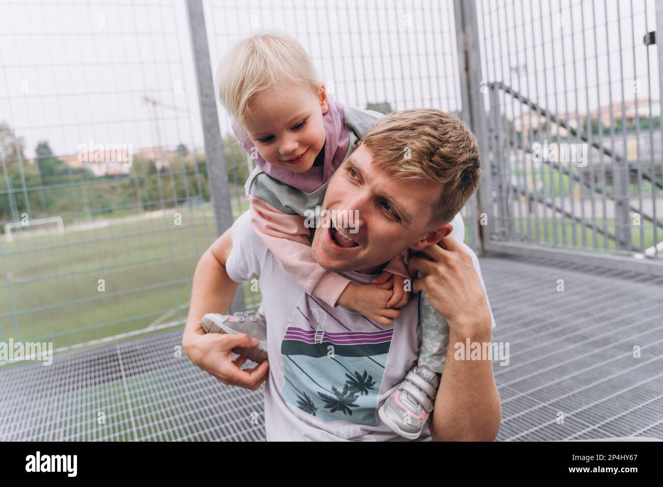 Dad and baby daughter have fun near the football field stadium Stock ...