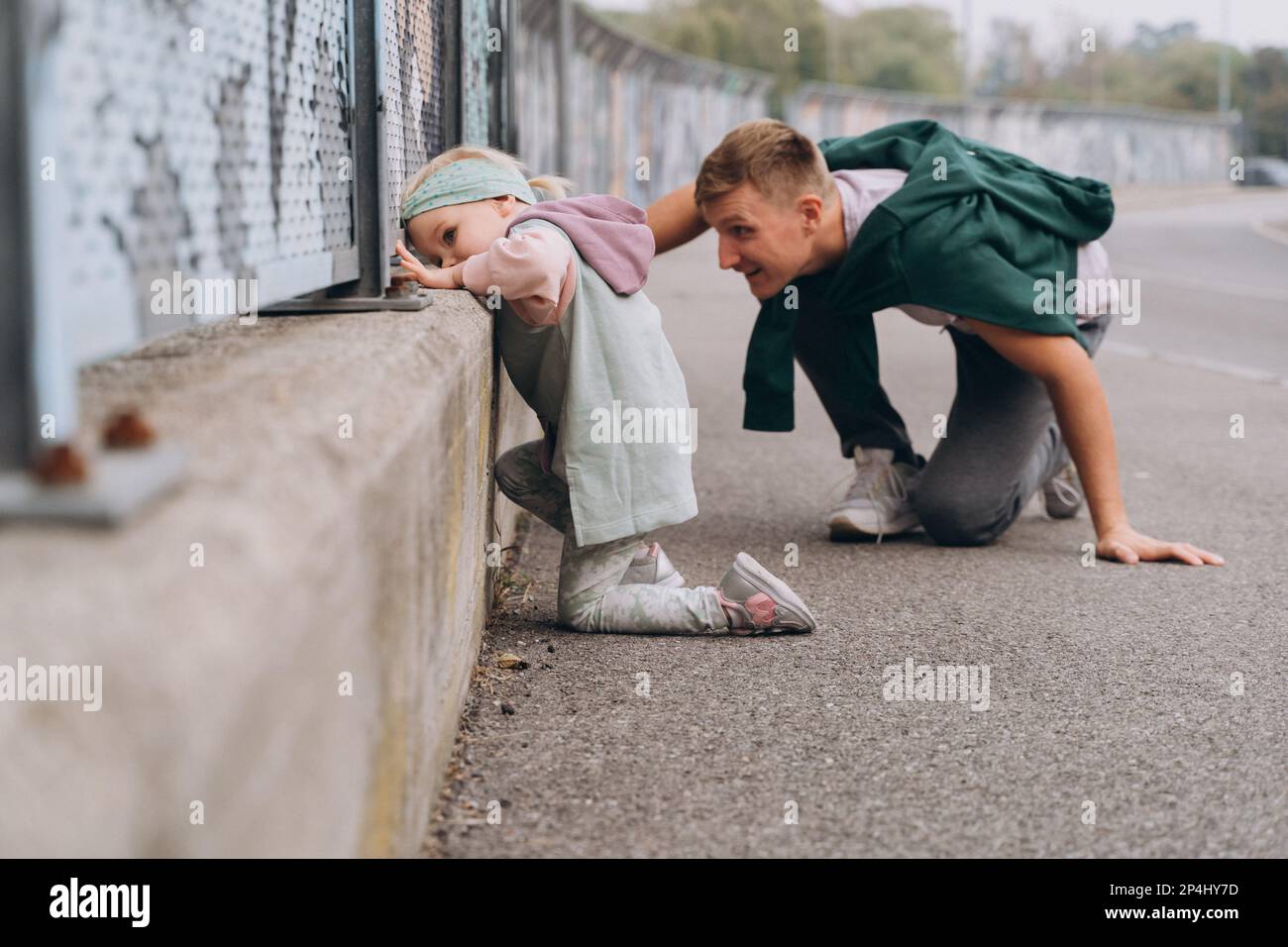 Dad and baby daughter look under someone else's fence Stock Photo - Alamy