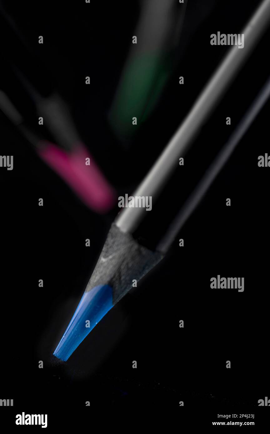 Colored pencils with a black base fly apart in a black space Stock ...