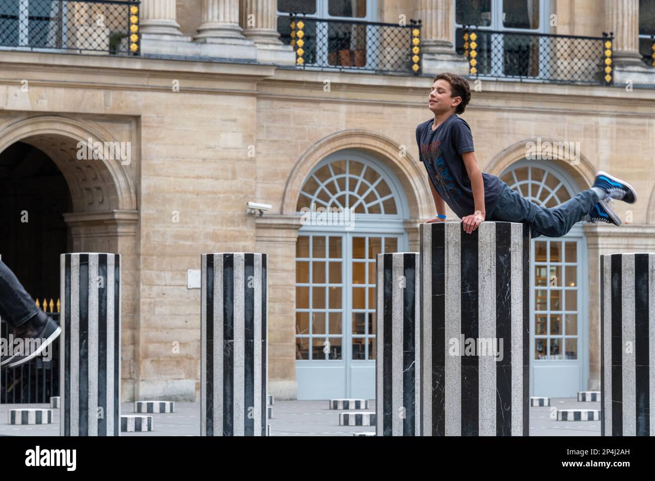 A boy plays on the Colonnes de Buren/Les Deux Plateaux art installation ...