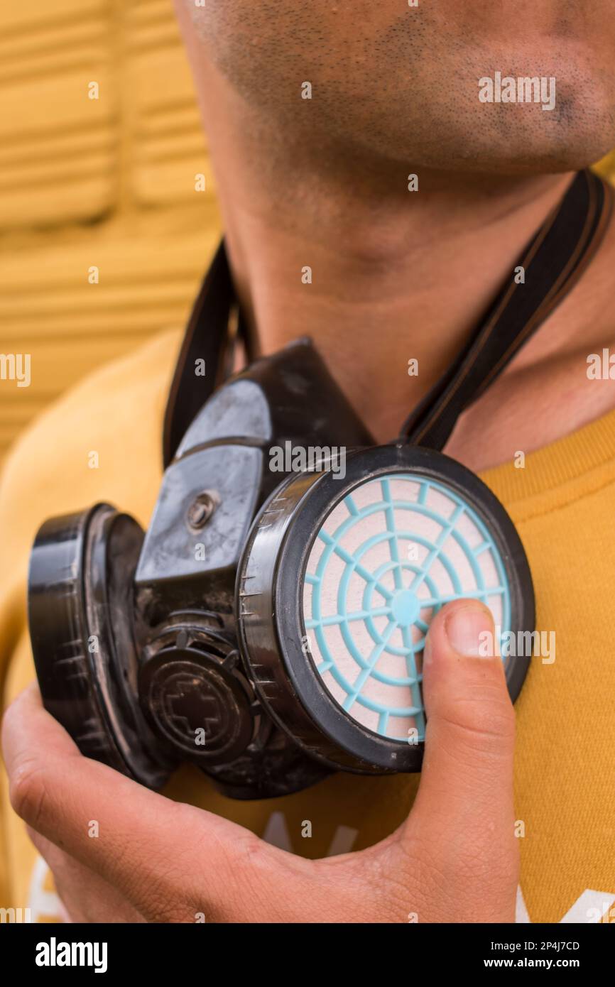 Man holding a gas mask on yellow background Stock Photo - Alamy
