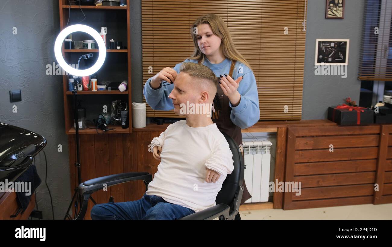 a man with disabilities gets his hair cut and styled in a barber shop ...